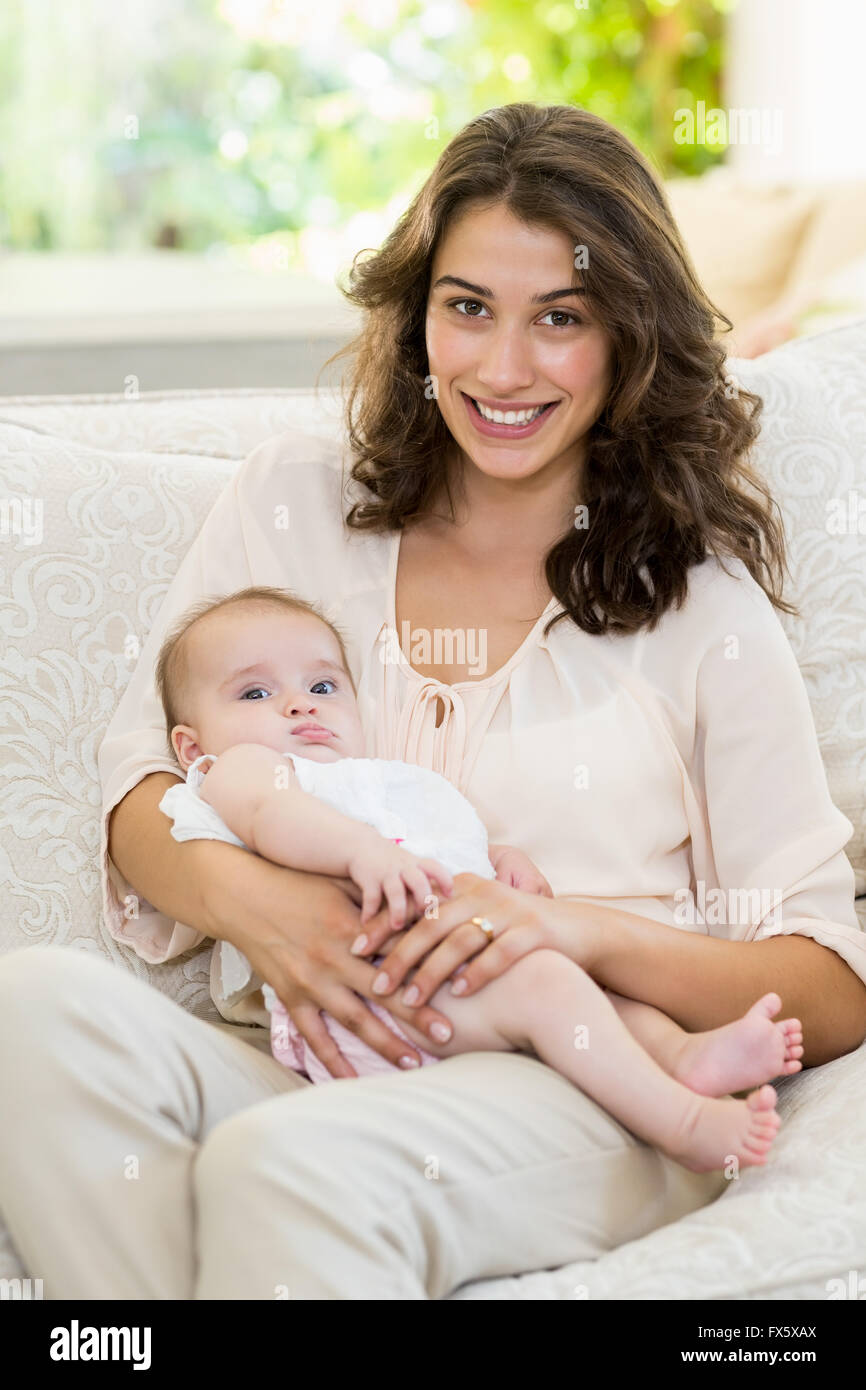 Mother holding her baby on lap in living room Stock Photo - Alamy