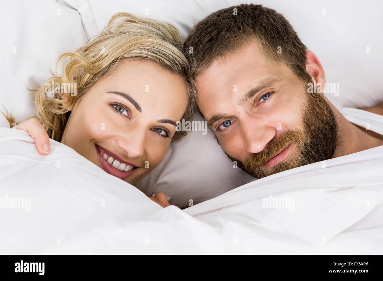 Portrait of couple smiling on bed Stock Photo - Alamy