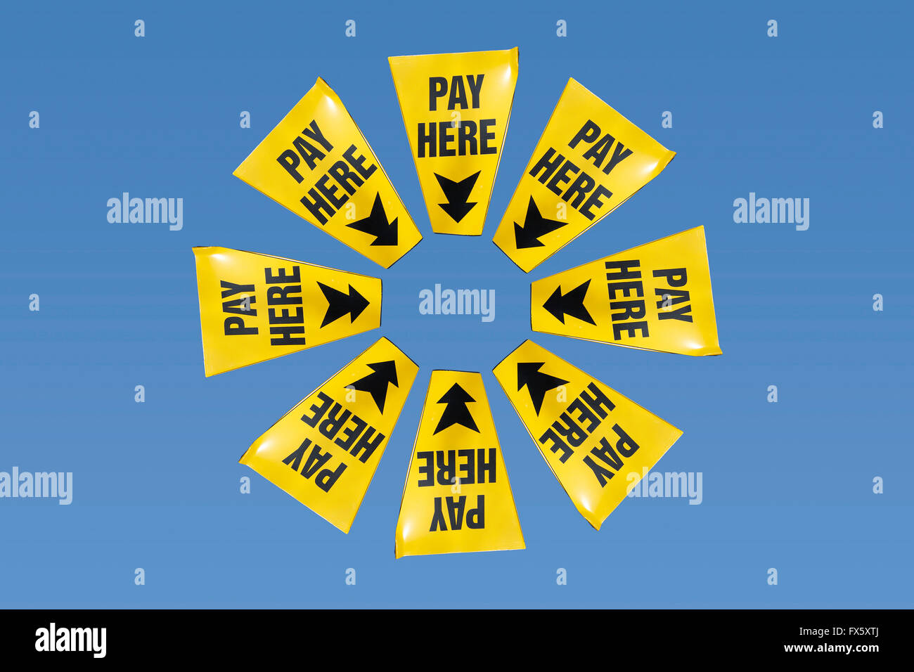 Yellow Pay Here signs pointing to the centre Stock Photo - Alamy
