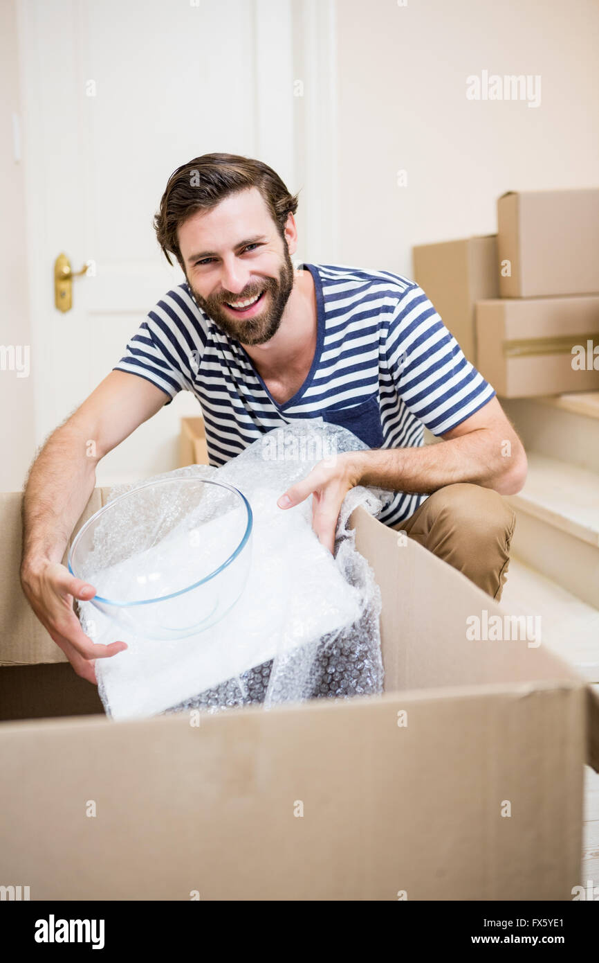 Young man unpacking carton boxes Stock Photo - Alamy