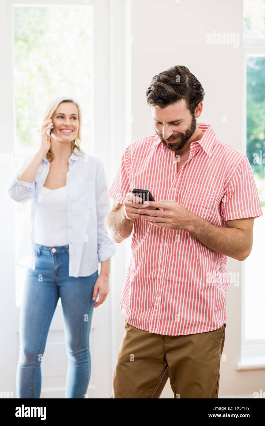 Man texting messaging while woman talking on mobile phone Stock Photo ...