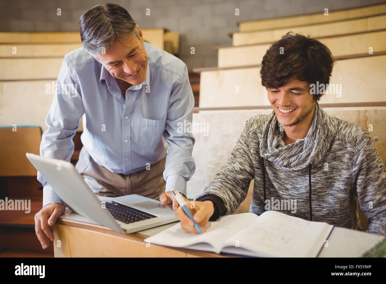 Professor helping a student in classroom Stock Photo - Alamy