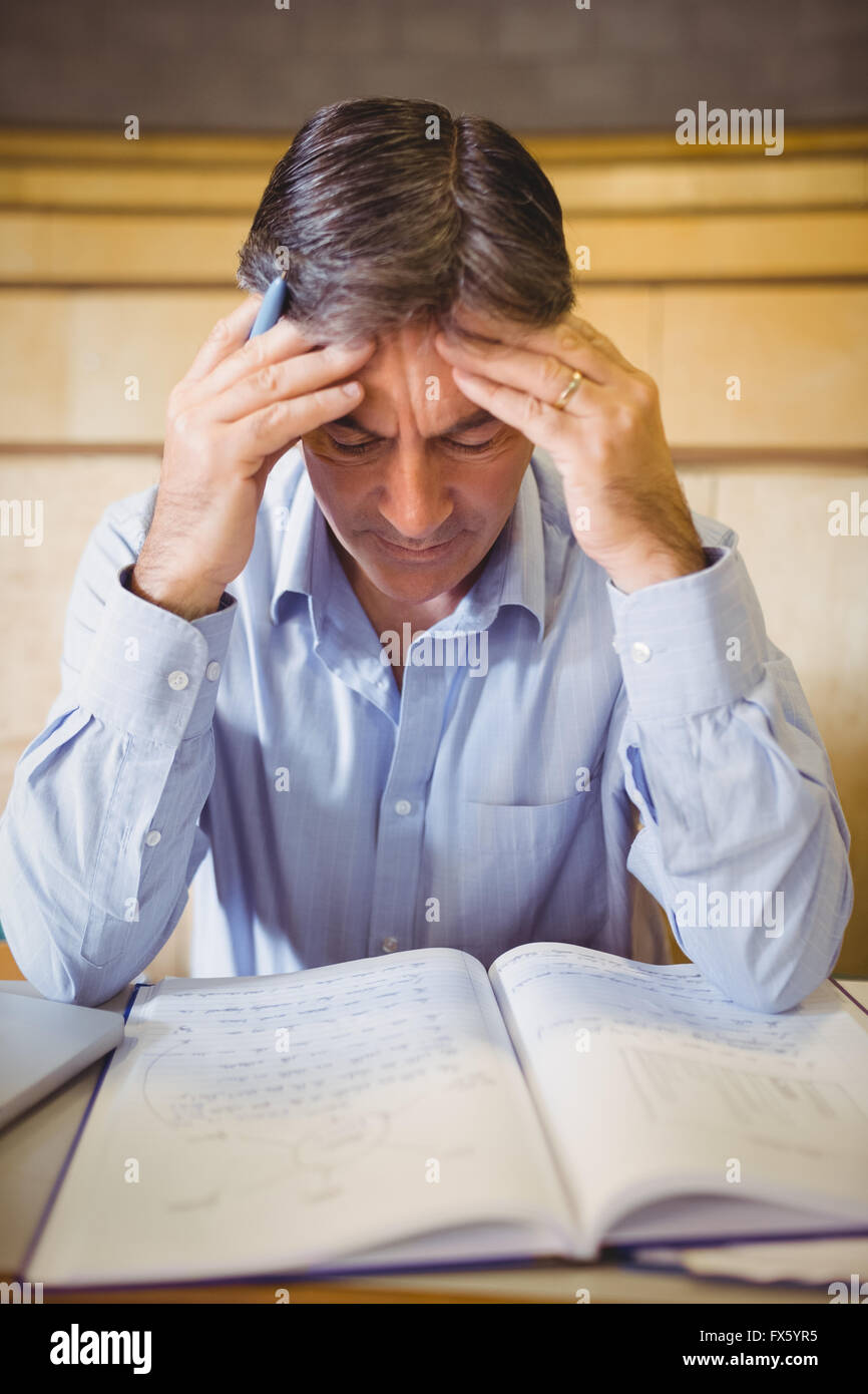 Depressed professor sitting with notes at desk Stock Photo - Alamy