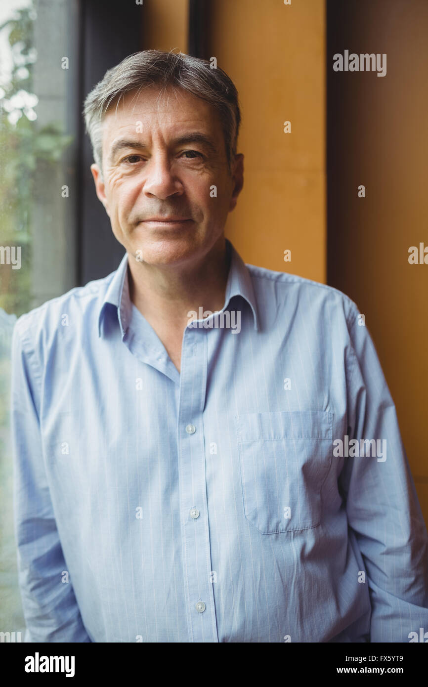 Portrait of professor standing near window Stock Photo - Alamy