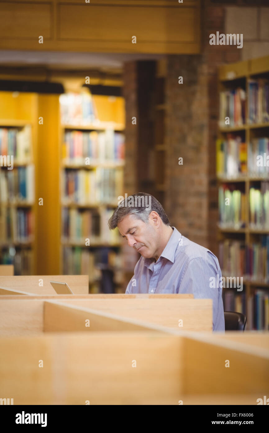 Professor sitting on desk using his laptop Stock Photo - Alamy