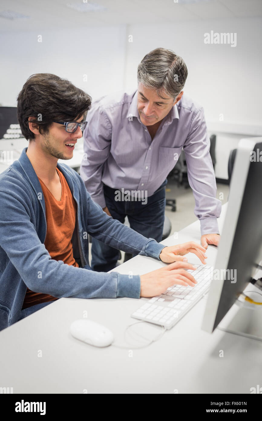 Computer teacher assisting a student Stock Photo - Alamy