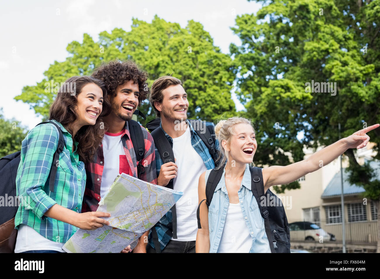 Friends holding map and pointing Stock Photo - Alamy