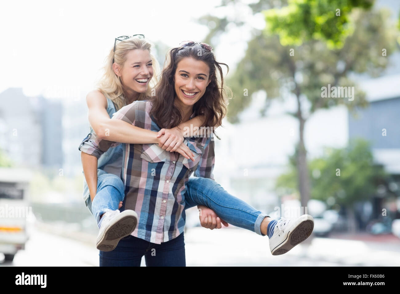 Woman giving piggyback to her friend Stock Photo - Alamy