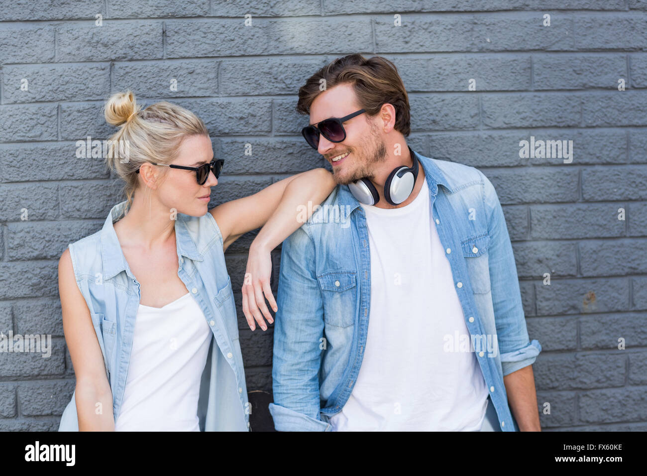 Young couple leaning against wall Stock Photo - Alamy