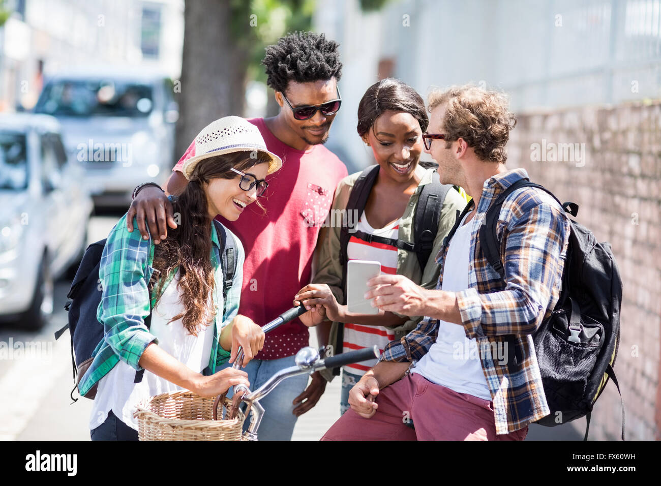Man showing mobile phone to his friends Stock Photo - Alamy