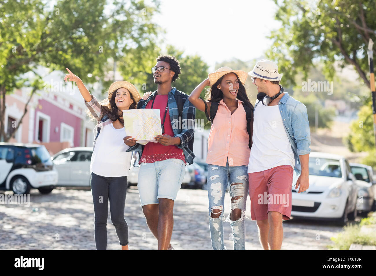 Friends holding map and pointing Stock Photo - Alamy