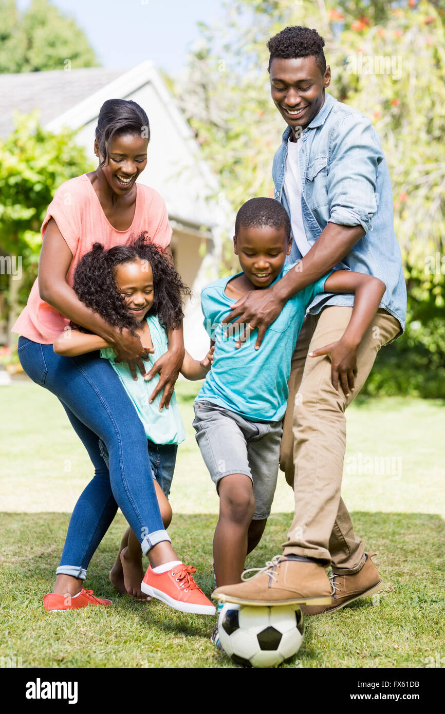Happy family playing football Stock Photo - Alamy