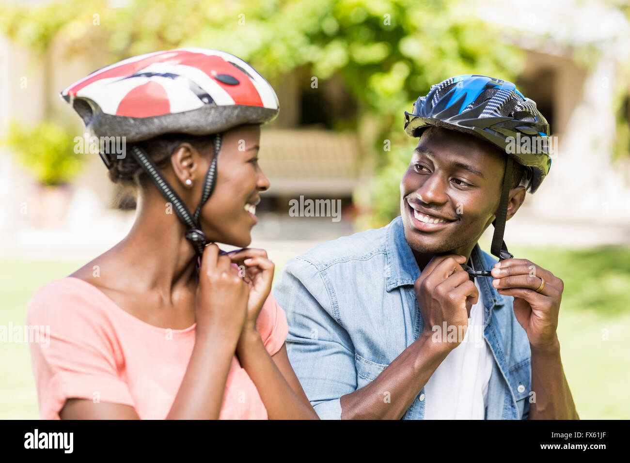 Happy couple wearing their helmet Stock Photo - Alamy