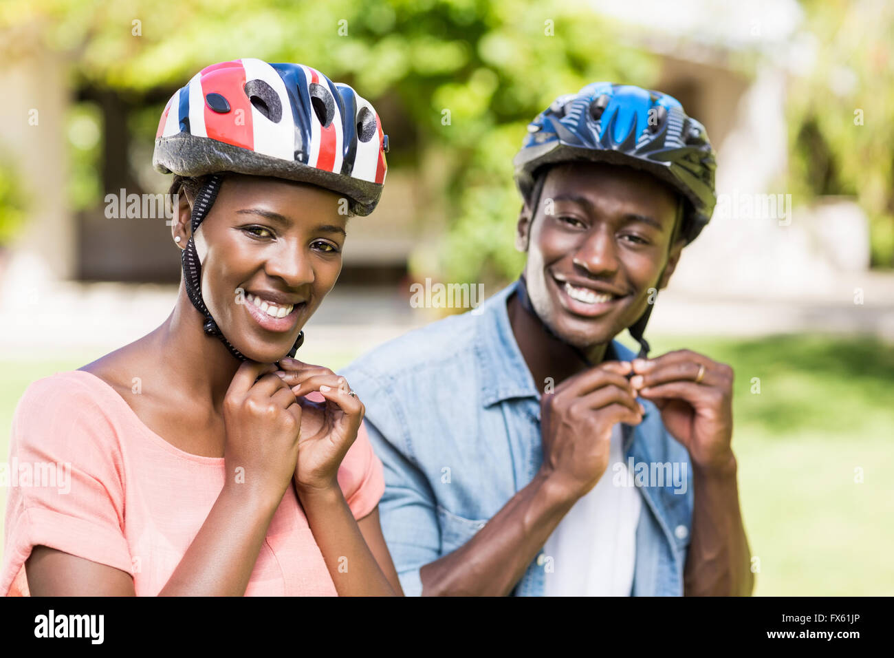 Happy couple wearing their helmet Stock Photo - Alamy