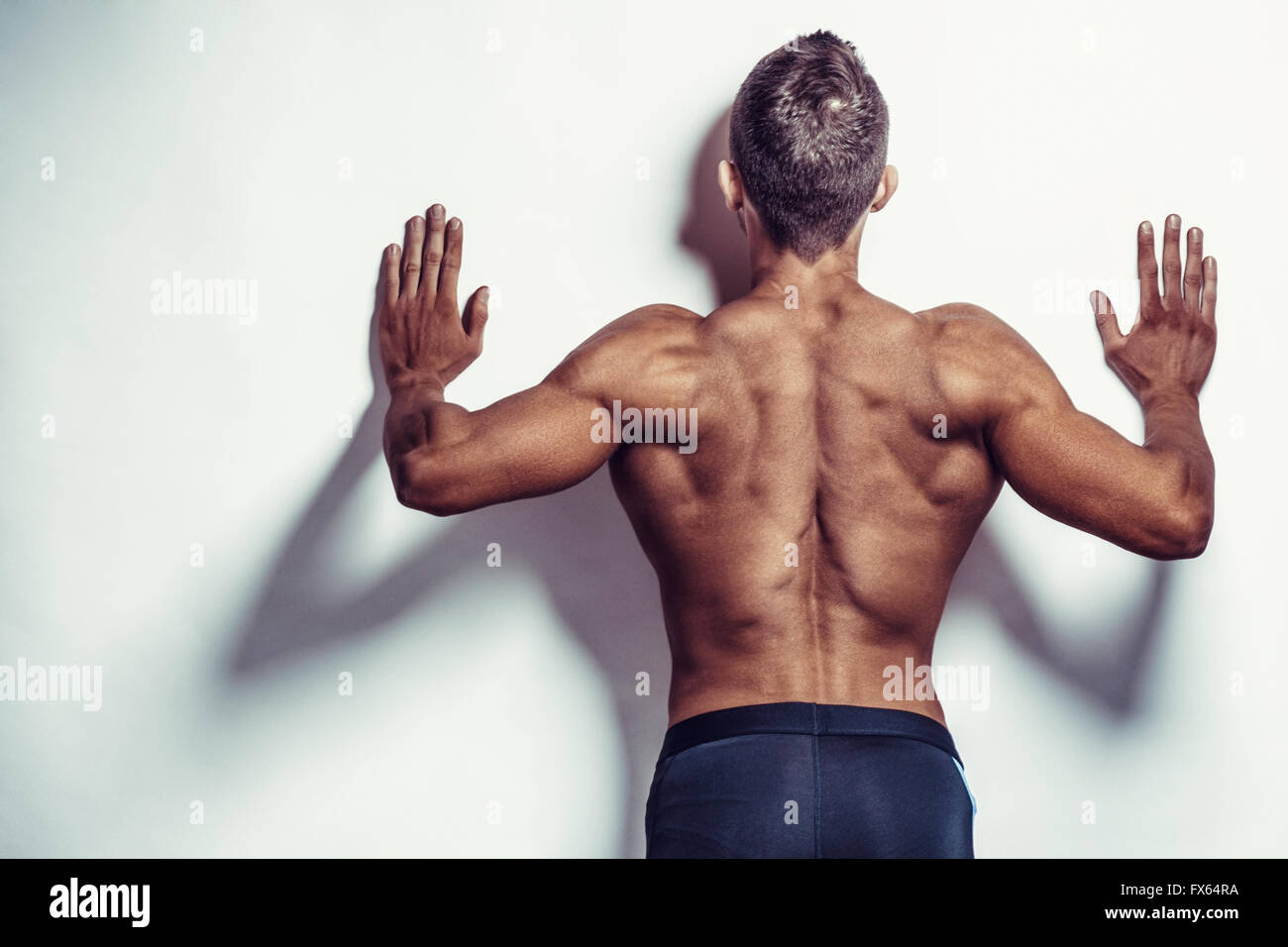 Muscle man dmaking push ups in studio, isolated over a white background ...