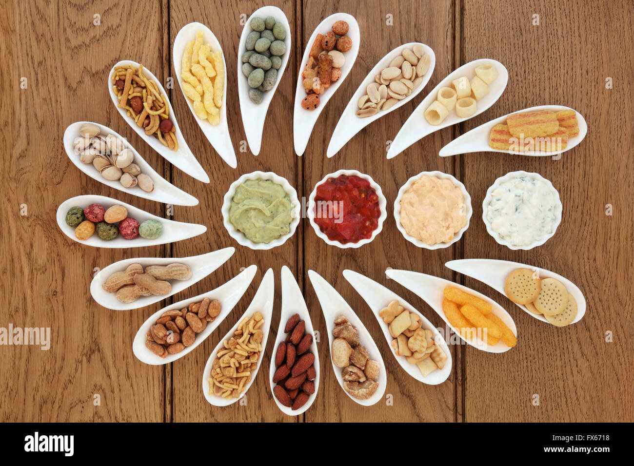 Savory snack and dip food selection in porcelain dishes over oak ...