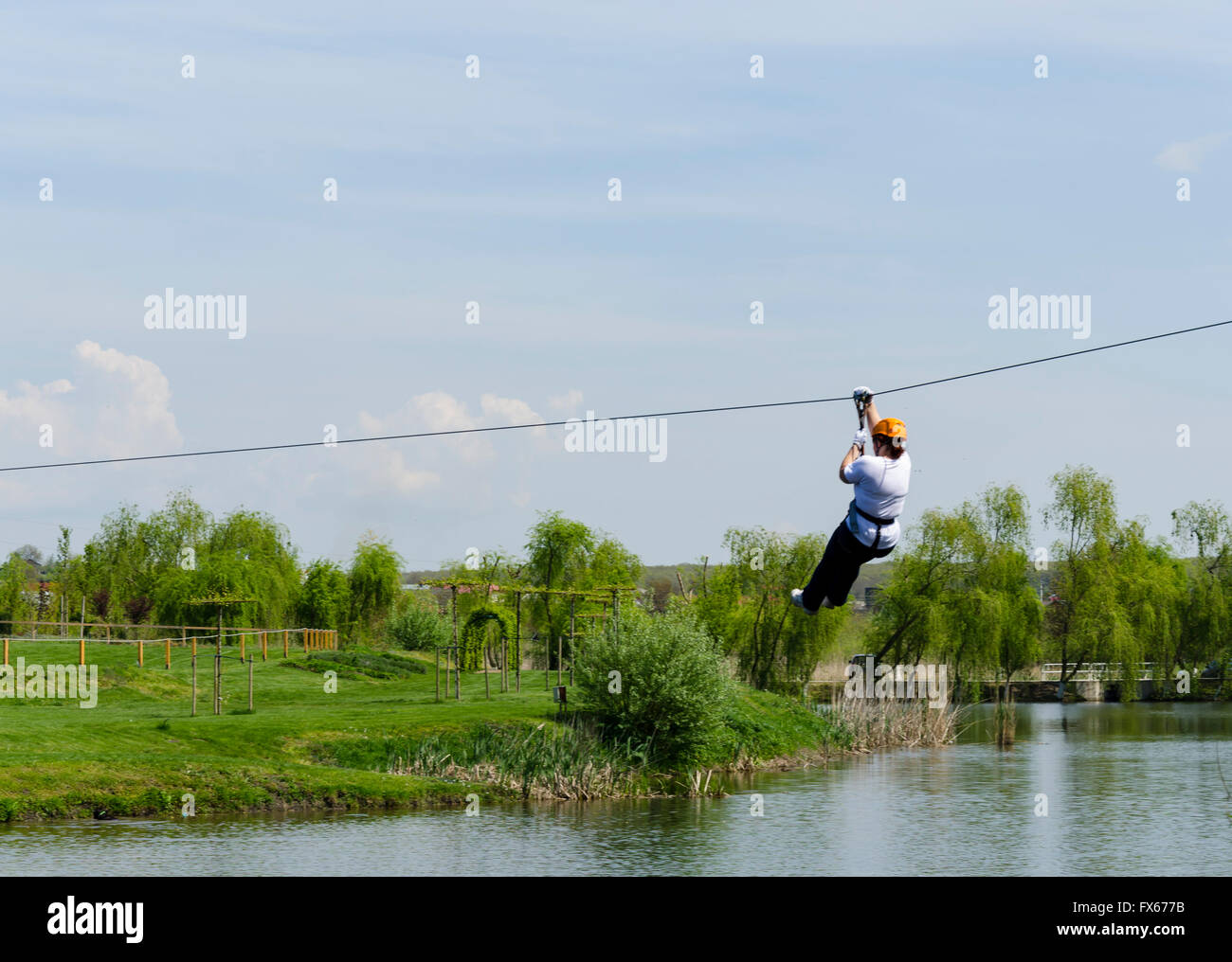 Girl riding a zip line in Comana Adventure Park in Neajlov Delta Stock ...