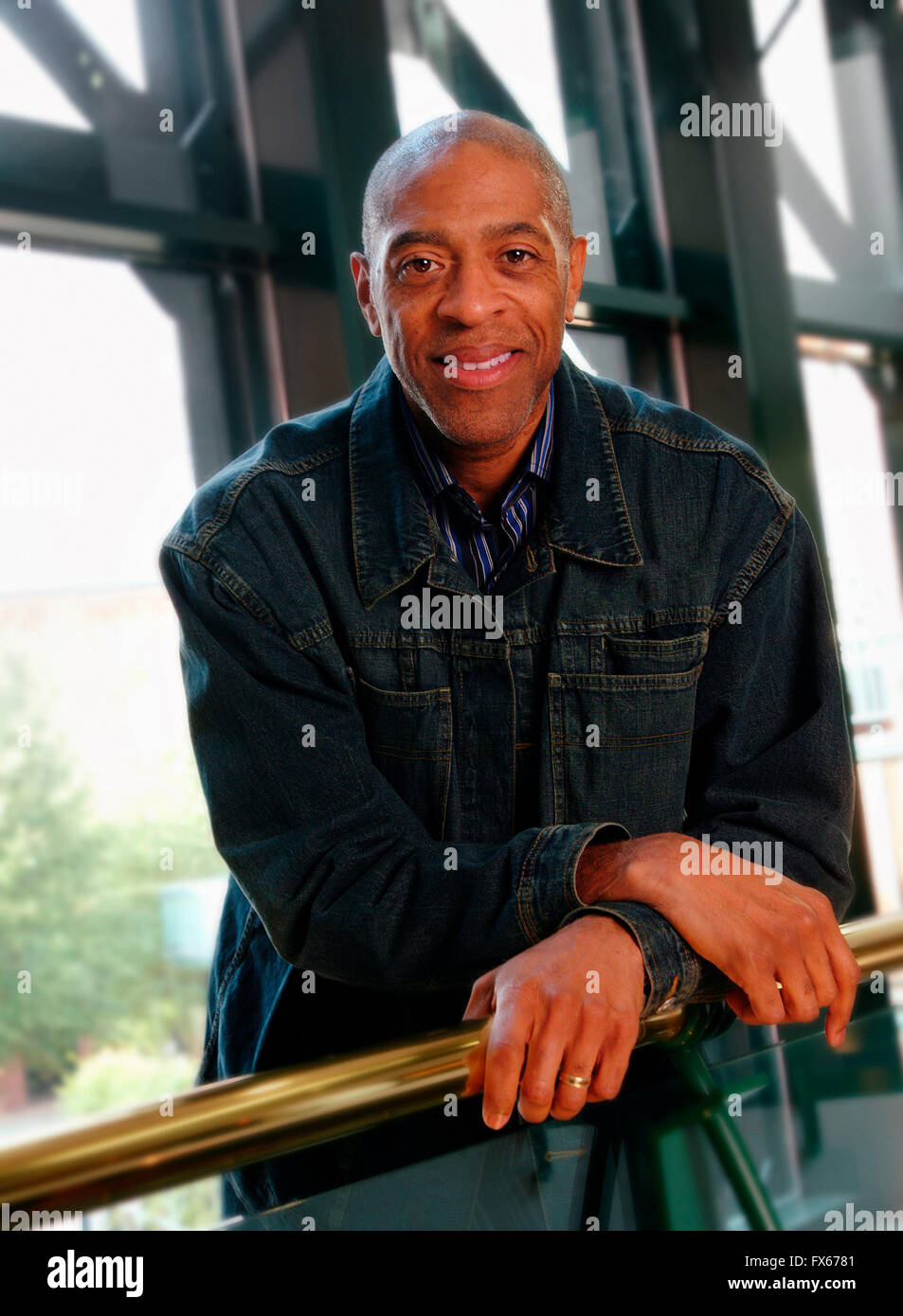Smiling man leaning on banister Stock Photo - Alamy