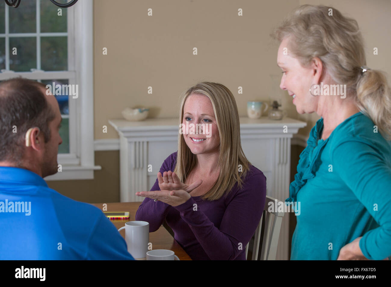 Deaf Caucasian friends signing at dinner table Stock Photo - Alamy