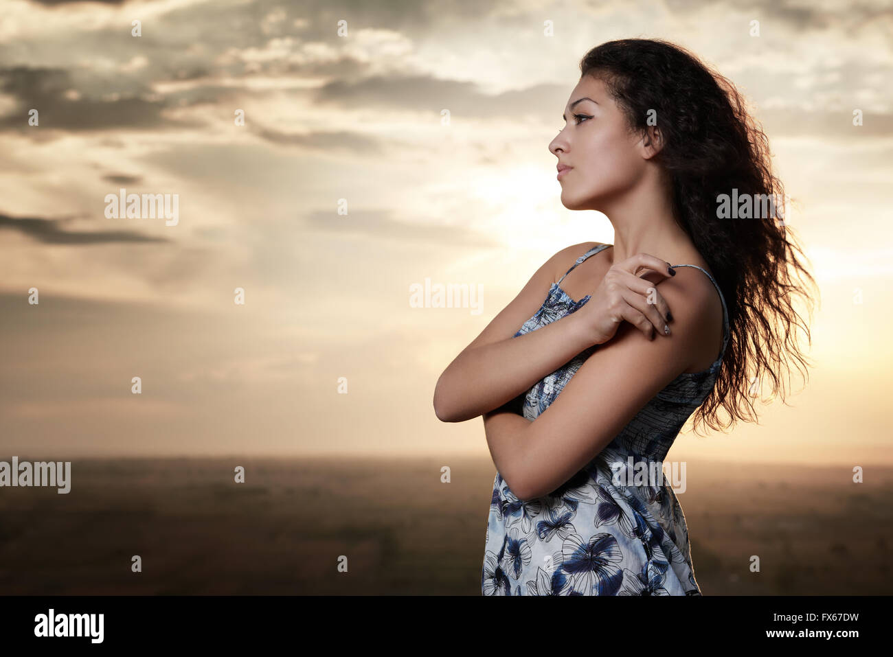 girl portrait at sunset on evening sky background Stock Photo - Alamy