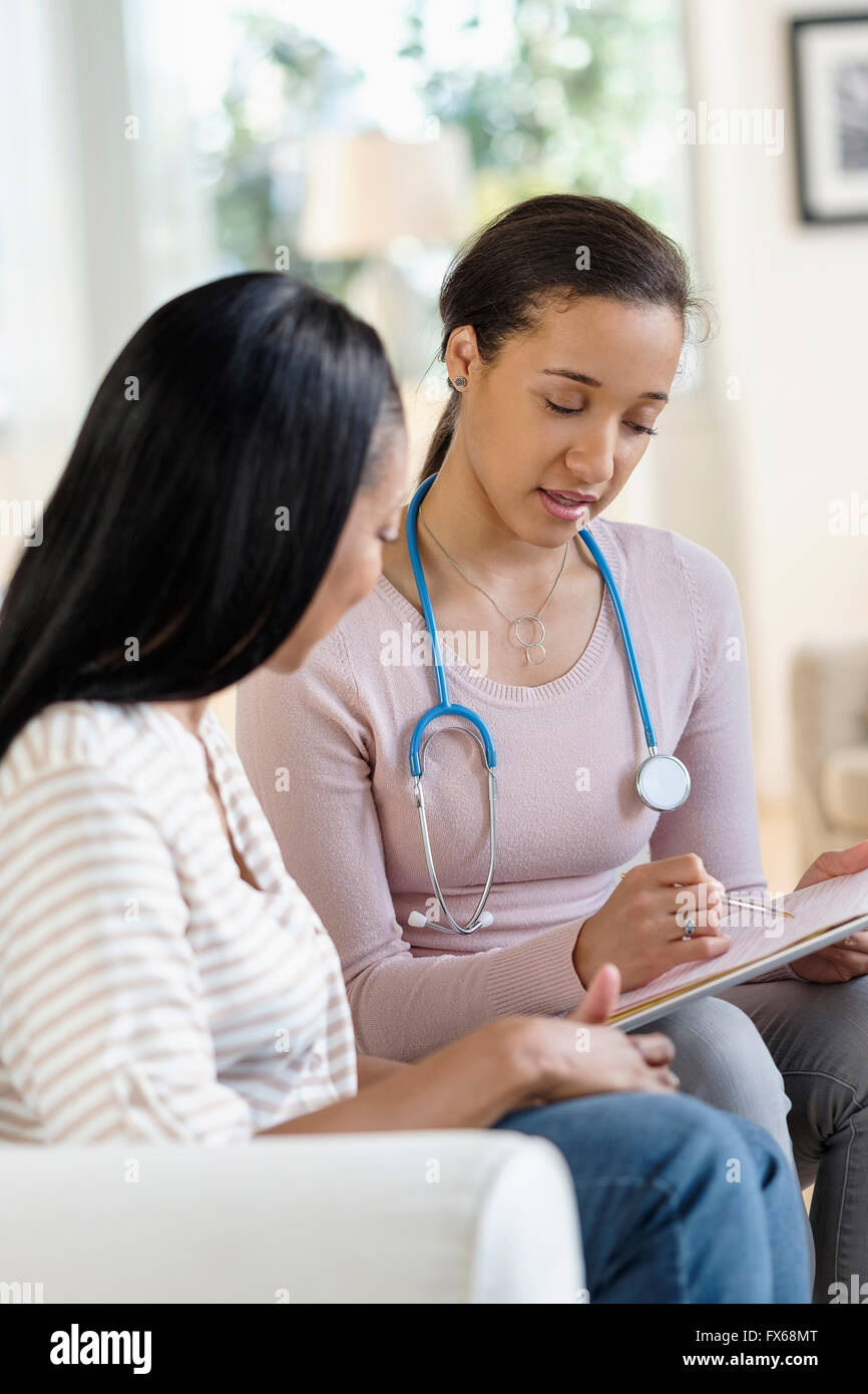 Doctor and patient talking in living room Stock Photo - Alamy