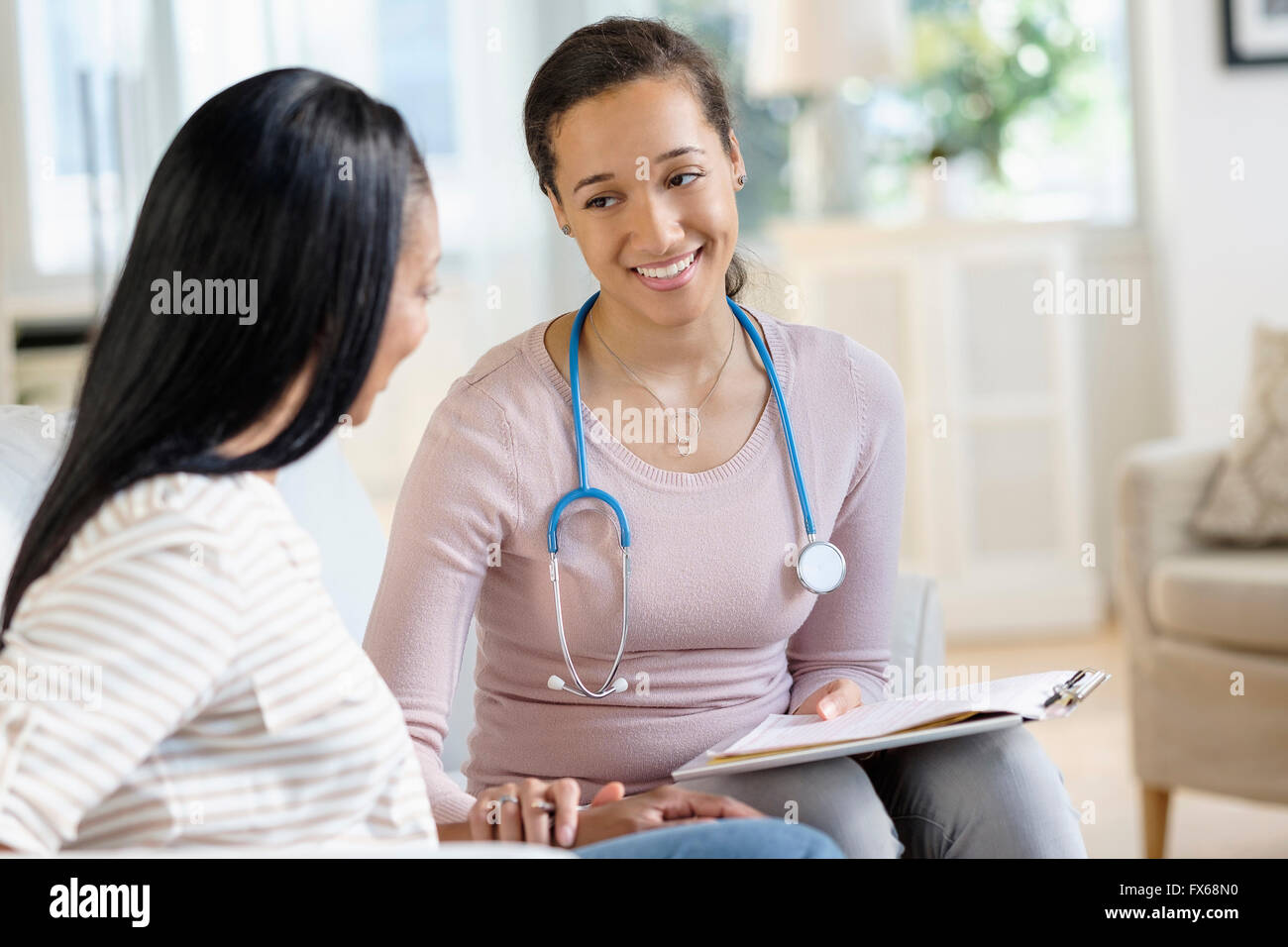 Doctor comforting patient in living room Stock Photo - Alamy