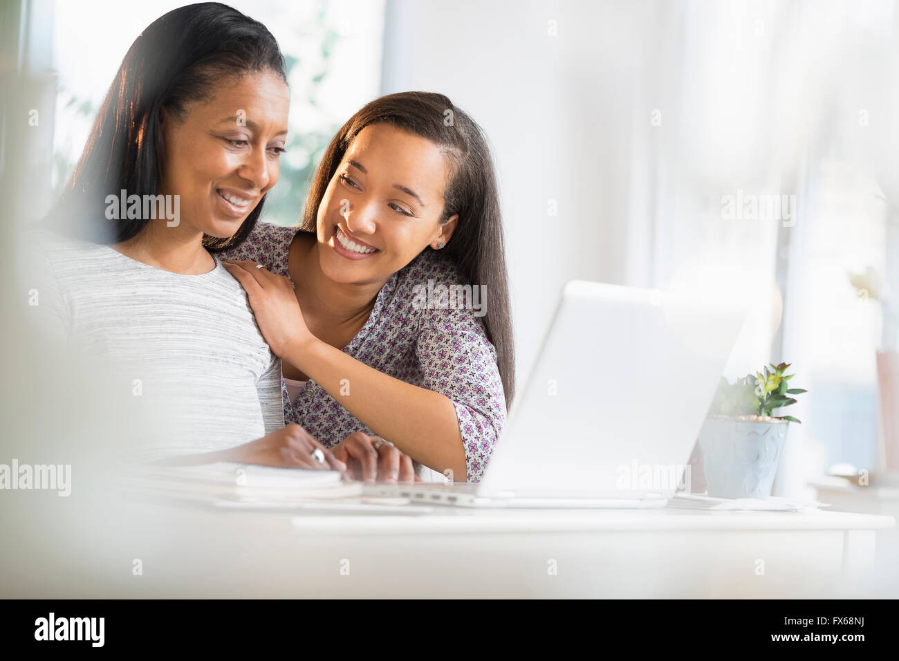 Mother and daughter using laptop Stock Photo - Alamy
