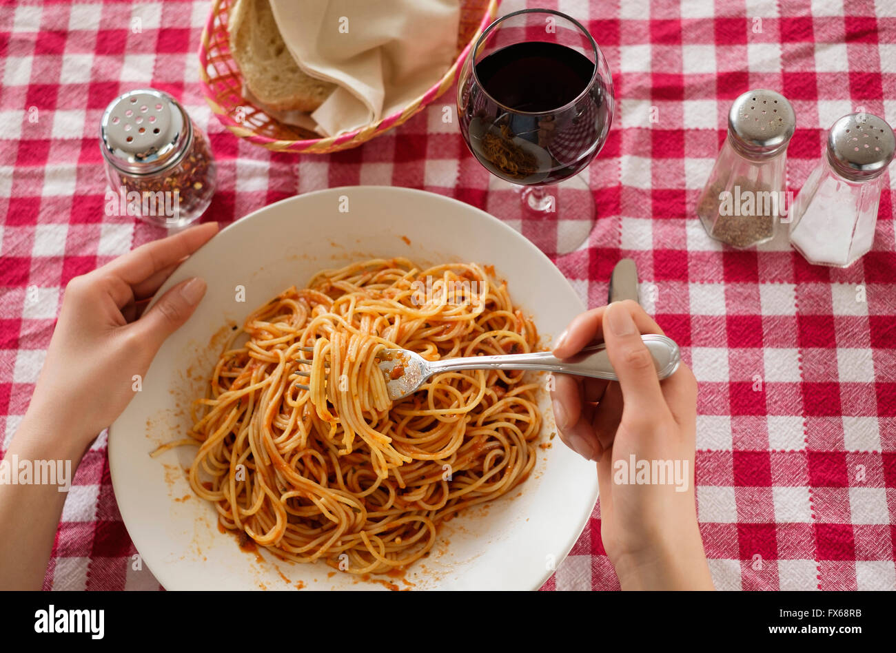 Hispanic woman eating plate of pasta Stock Photo - Alamy