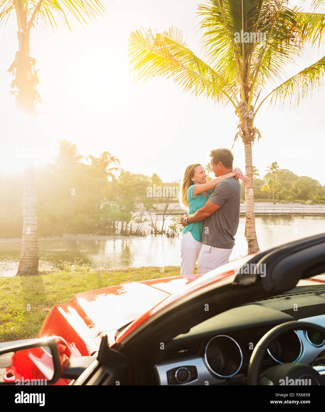 Caucasian couple hugging near convertible Stock Photo - Alamy