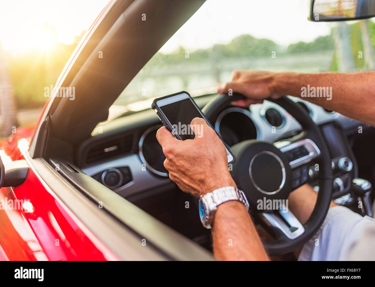 Caucasian man using cell phone and driving convertible Stock Photo - Alamy