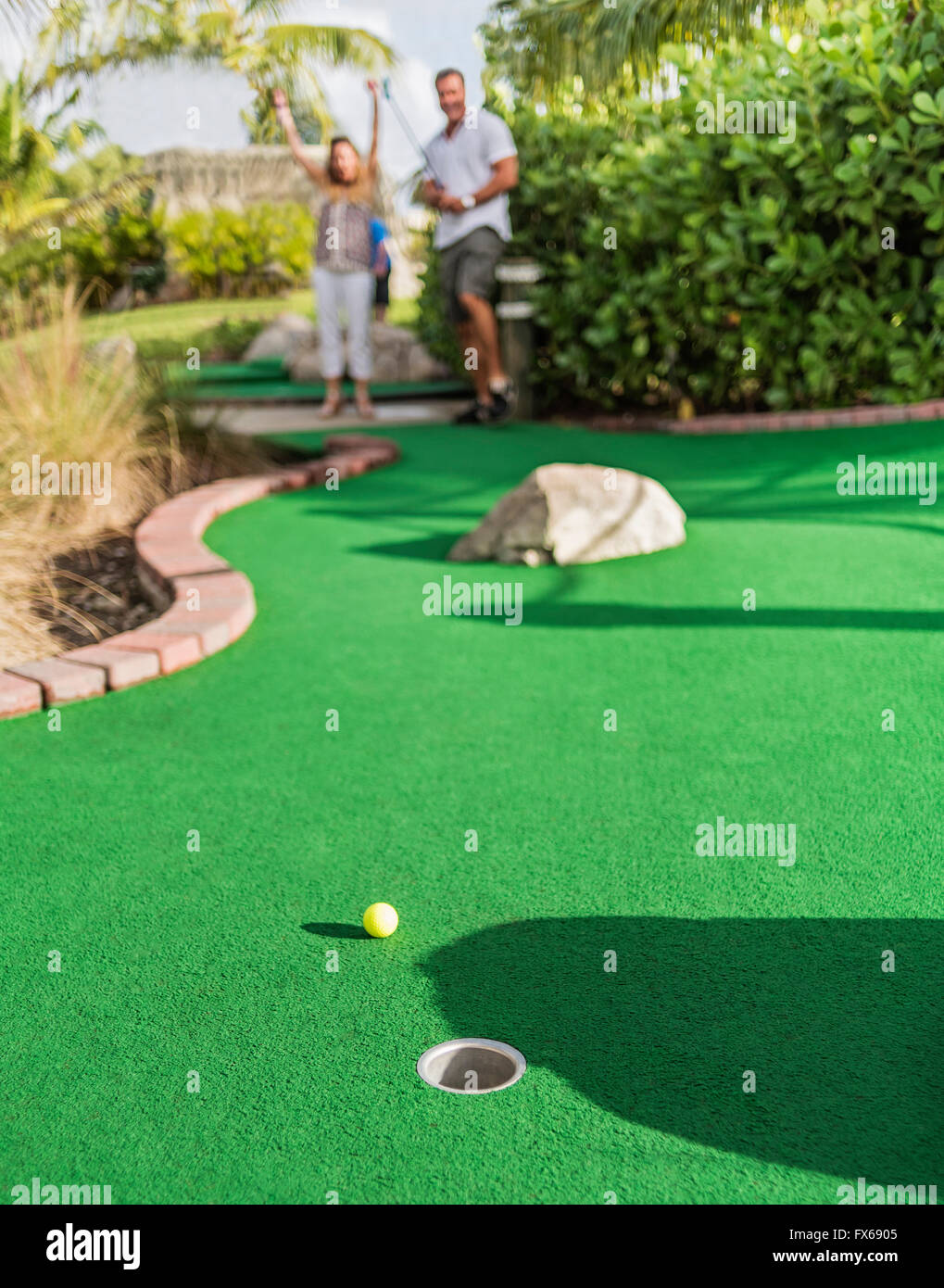 Caucasian couple playing miniature golf Stock Photo - Alamy