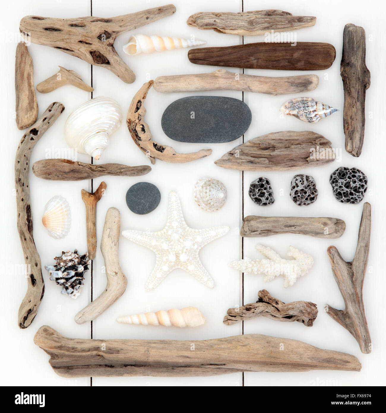 Shell, driftwood and pebble abstract collage over wooden white ...
