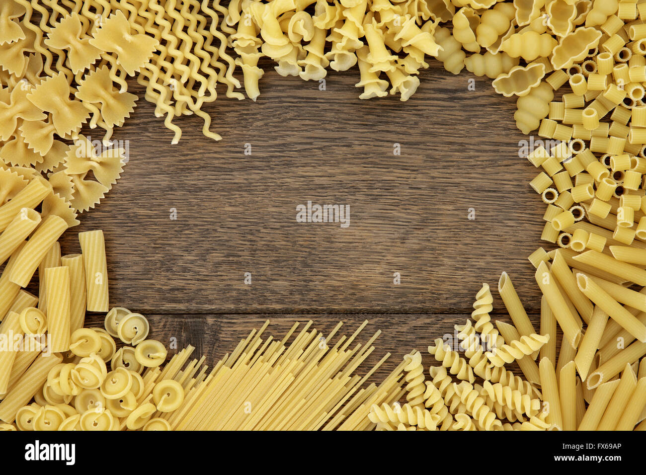 Pasta food selection forming an abstract background border over old oak ...