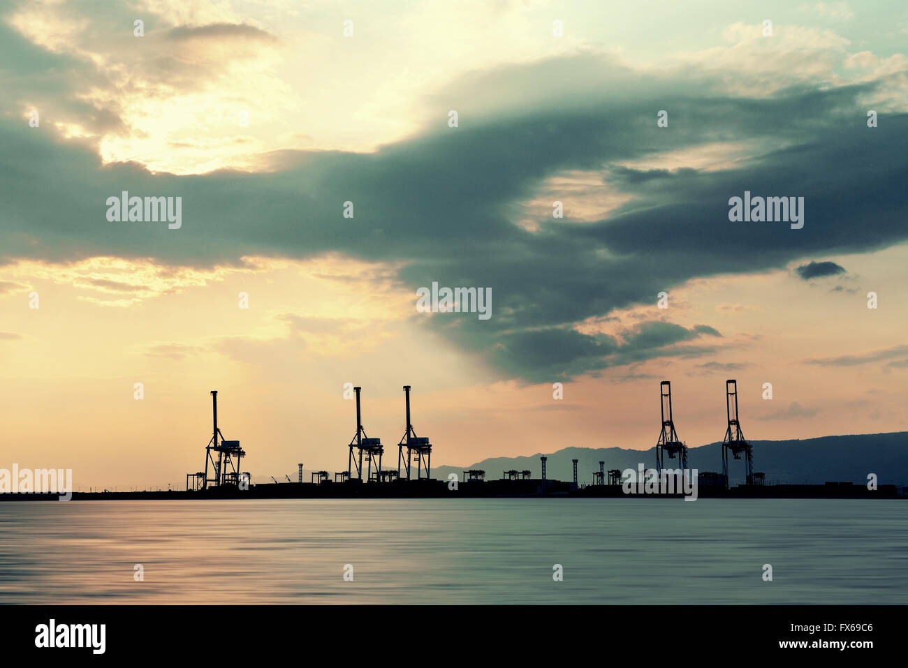 Osaka seaport with crane silhouette at sunset. Japan Stock Photo - Alamy
