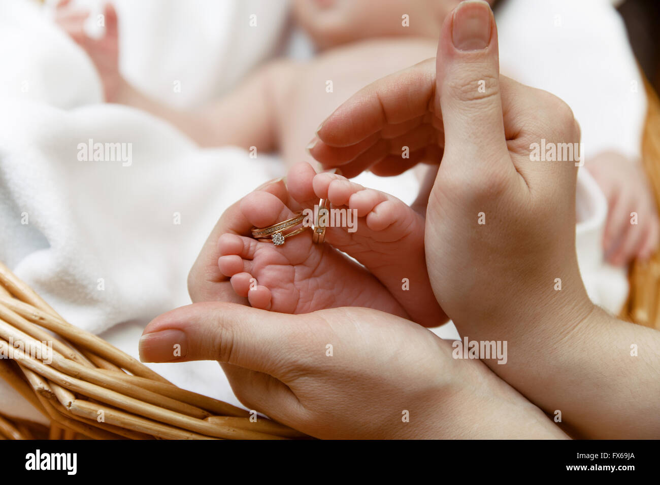 Baby's feet with wedding rings in mother's hands Stock Photo - Alamy
