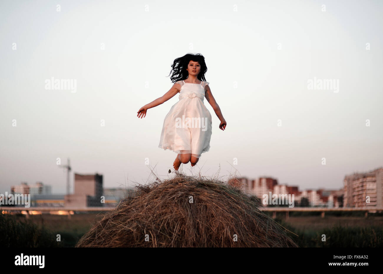 Caucasian woman jumping on haystack Stock Photo - Alamy