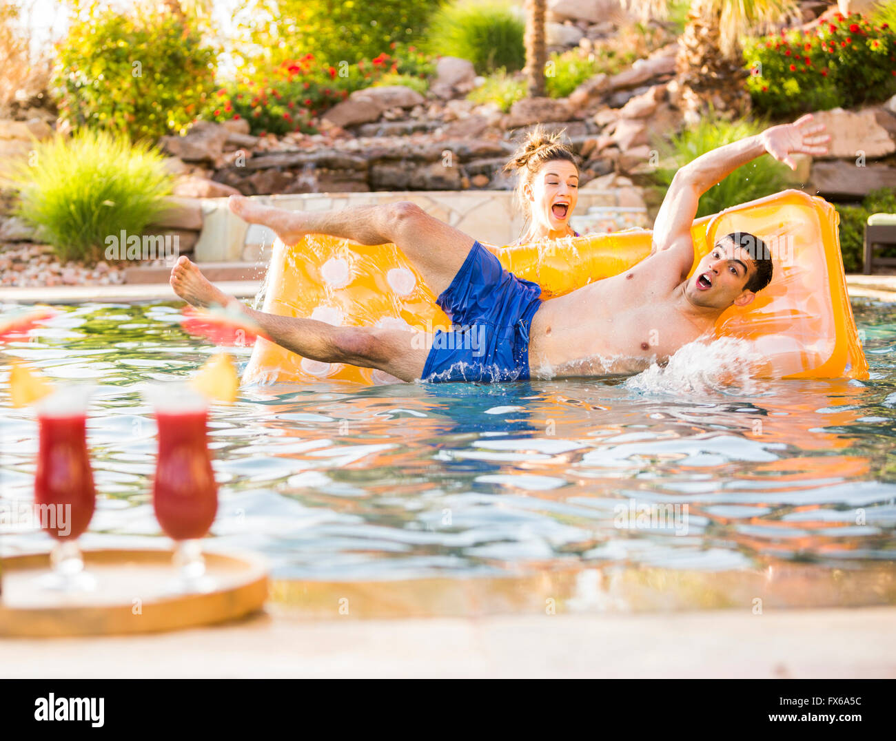 Woman pushing boyfriend in swimming pool Stock Photo - Alamy
