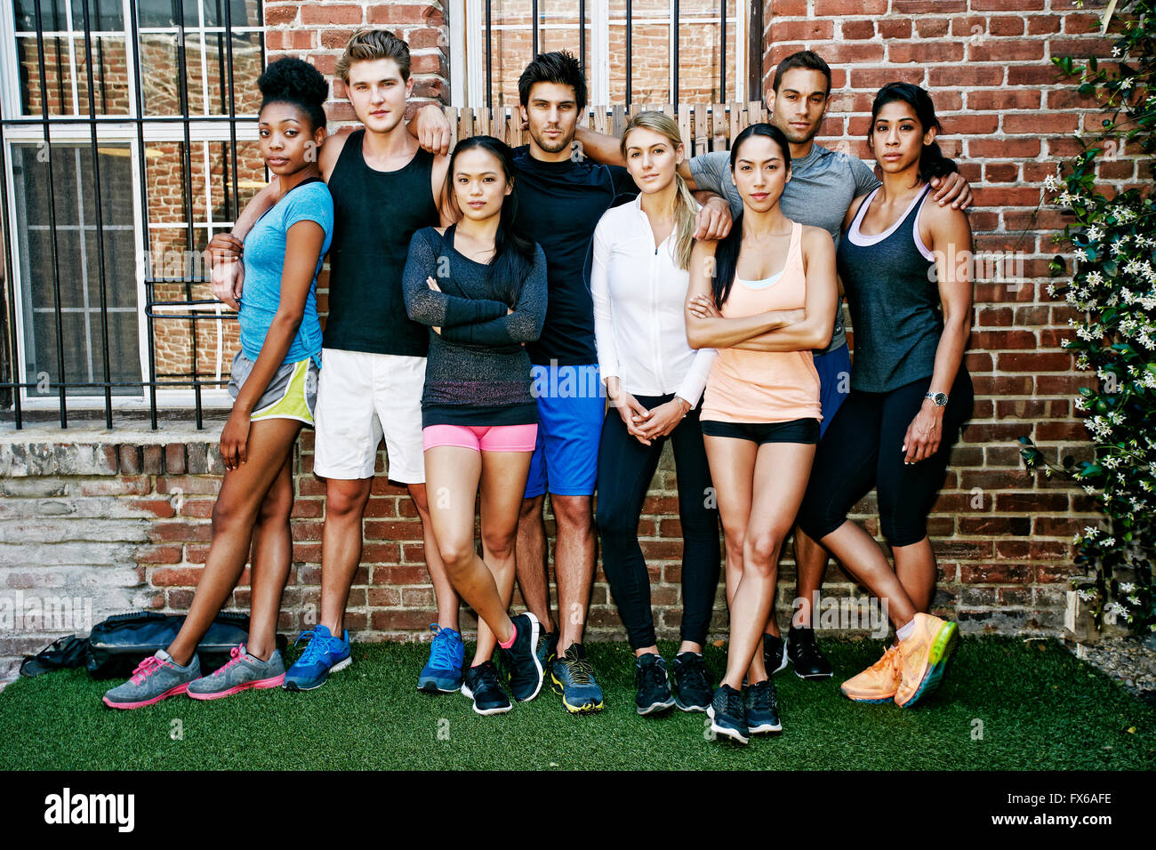 Friends leaning on brick wall Stock Photo - Alamy