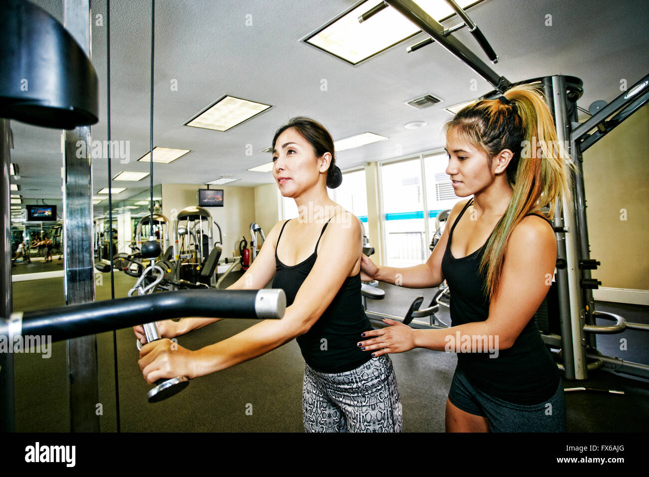 Female trainer assisting woman exercise hi-res stock photography and ...