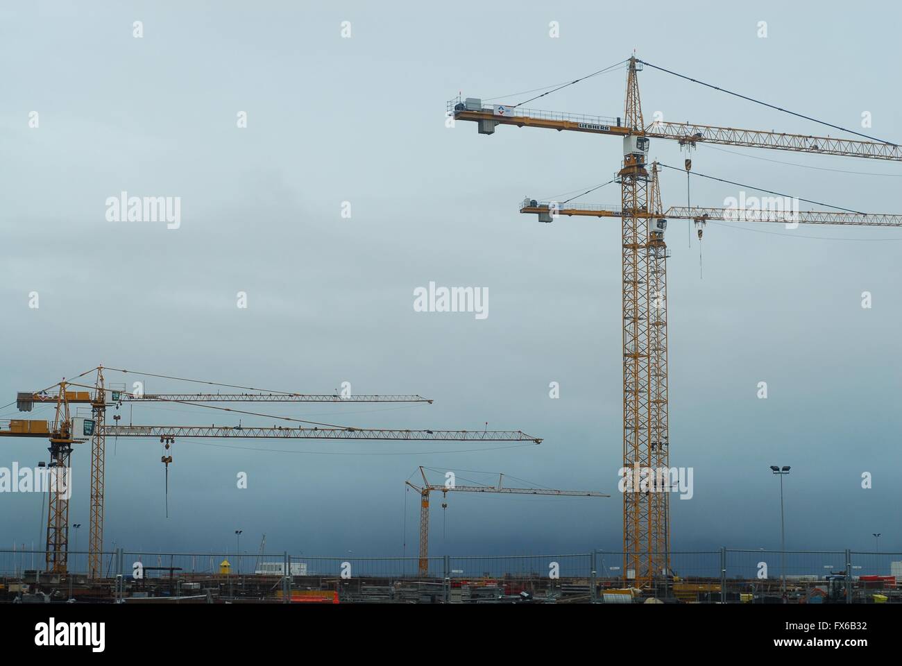 Five building cranes against an overcast sky Stock Photo - Alamy