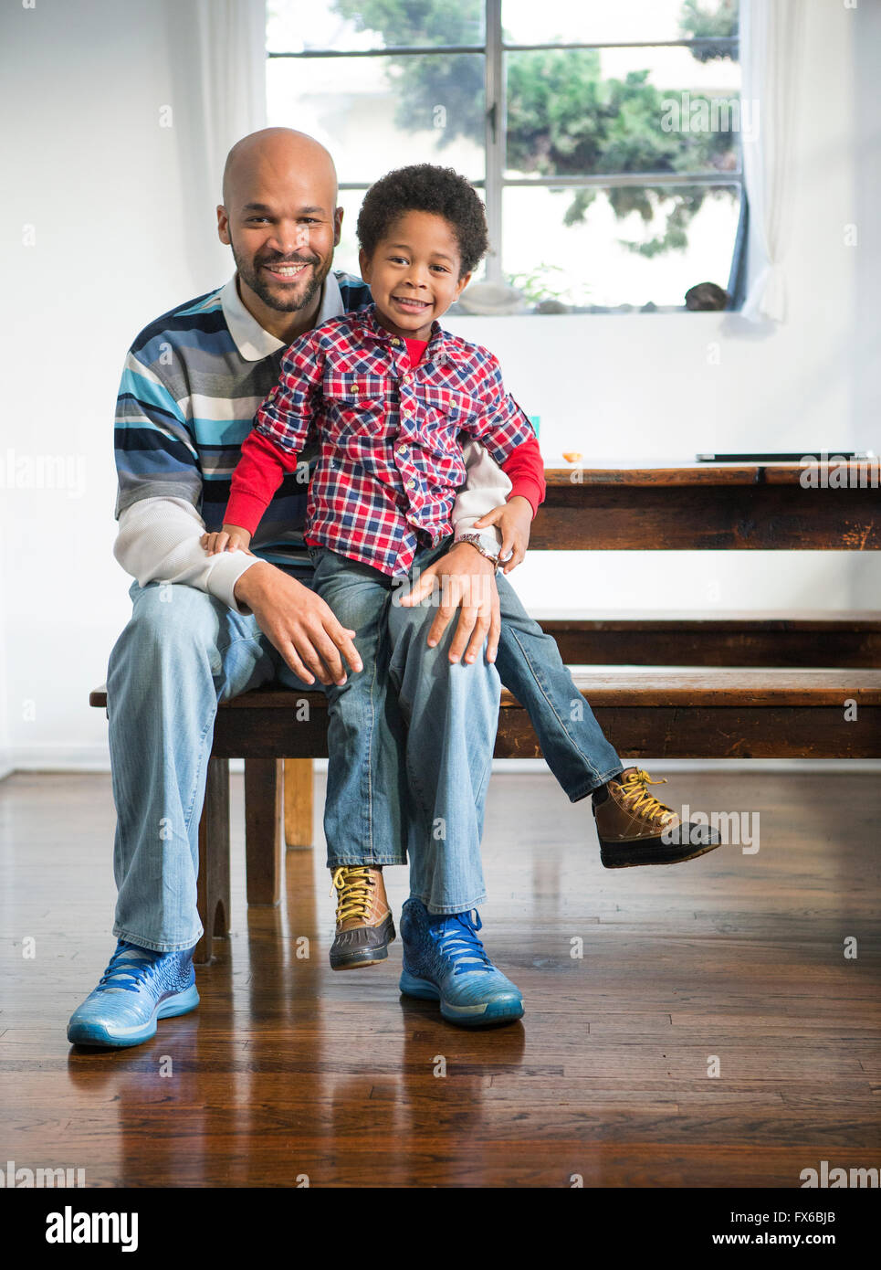Mixed race father and son smiling at table Stock Photo - Alamy