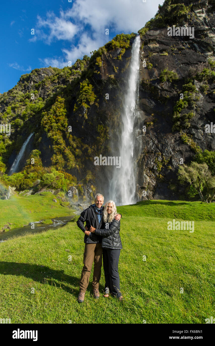 Caucasian couple hugging near remote waterfall Stock Photo - Alamy