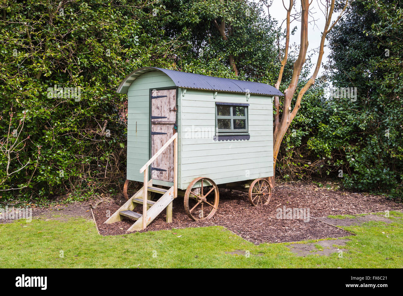 Old-fashioned vintage wooden shepherd's hut on rusty iron wheels which ...