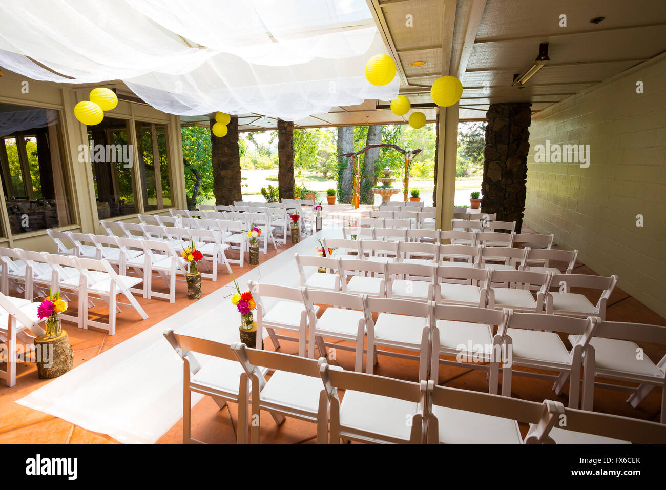White chairs and rows of seating create a nice venue for the bride to ...