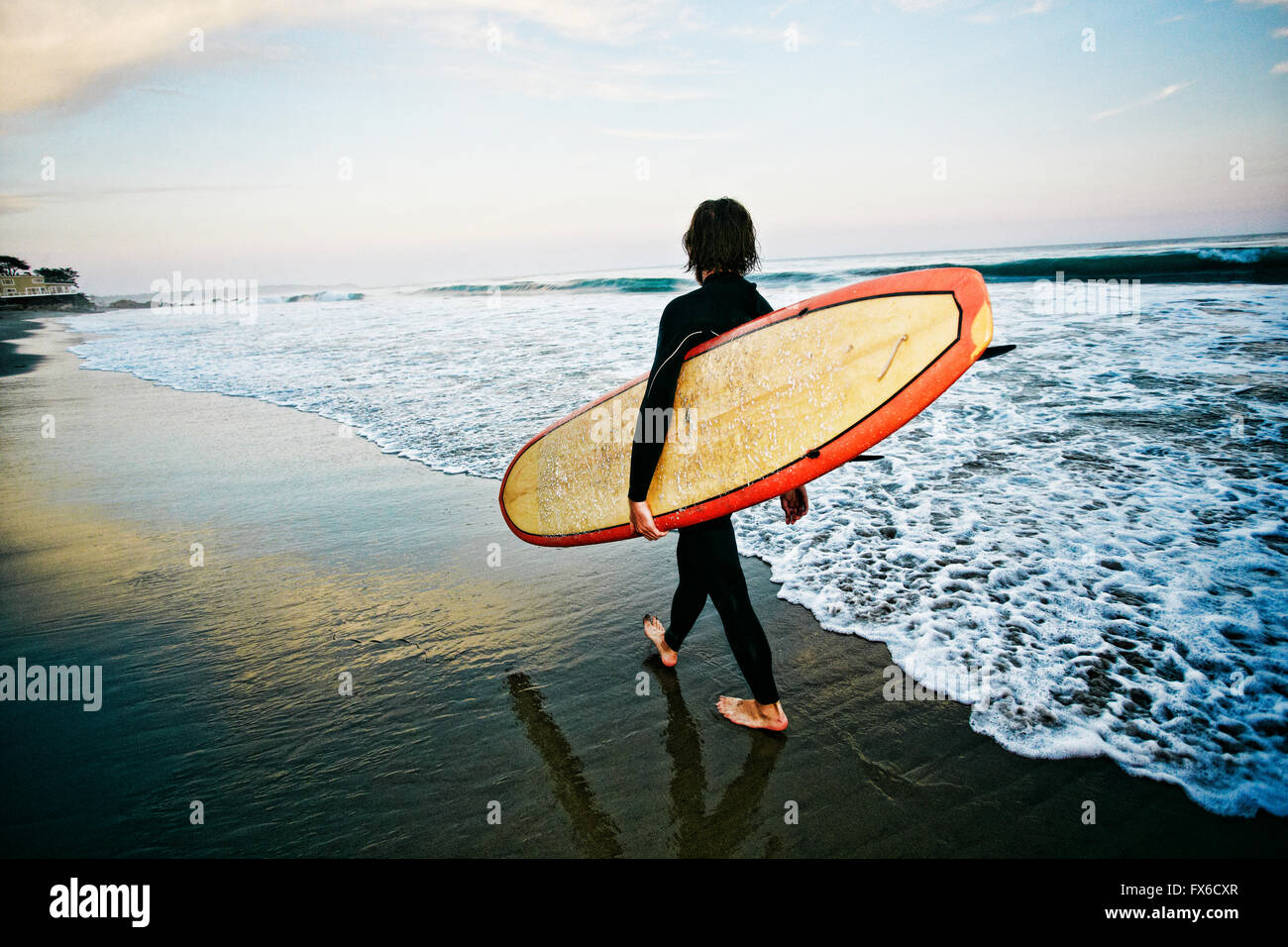 Caucasian man carrying surfboard at beach Stock Photo - Alamy
