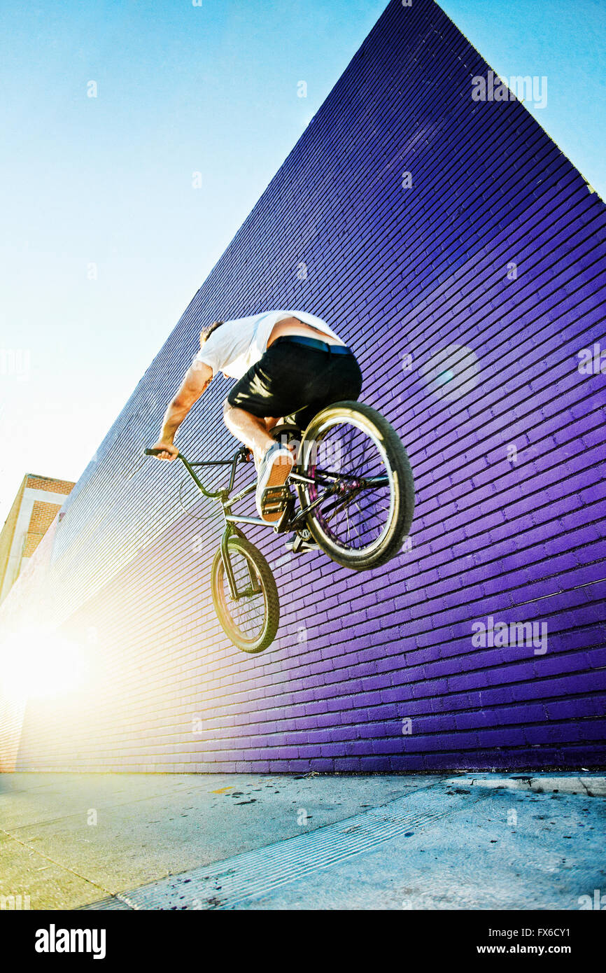 Caucasian man jumping on BMX bike Stock Photo - Alamy