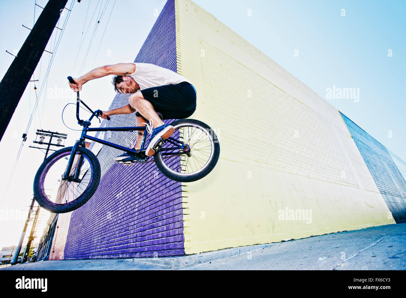 Caucasian man jumping on BMX bike on sidewalk Stock Photo - Alamy