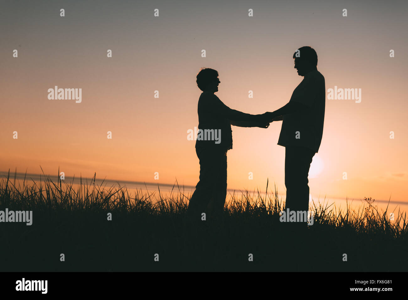 Adult couple silhouettes at sunset Stock Photo - Alamy