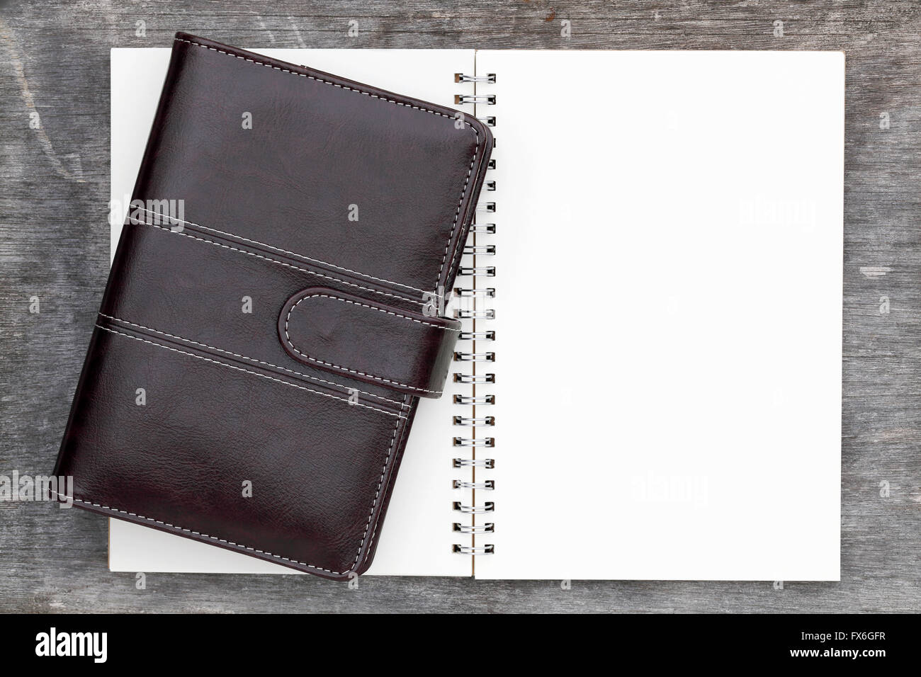 brown leather organizer and spiral notebook on grunge wood background ...