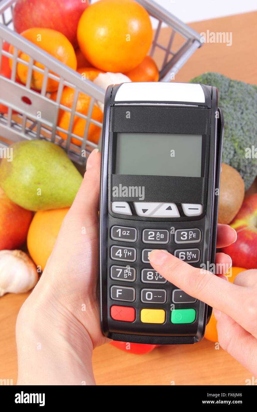 Hand of woman using payment terminal, enter personal identification ...
